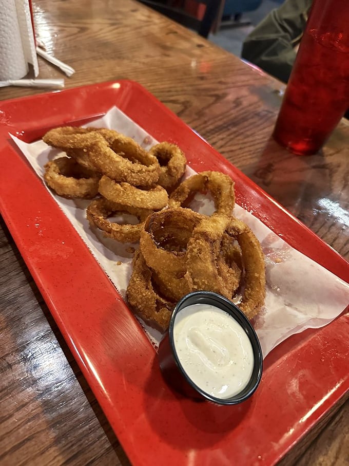 Onion rings wearing their golden armor proudly. Crispy, substantial, and ready to be dunked in that creamy dipping sauce&mdash;side dish royalty.