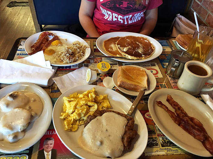Breakfast abundance that would make Ron Swanson weep with joy—pancakes, eggs, bacon, and biscuits with gravy.