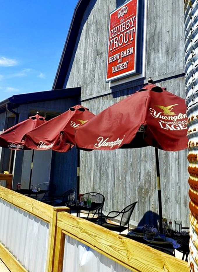 Red Yuengling umbrellas add a splash of color against the weathered barn exterior&mdash;creating a patio space that beckons you to linger over just one more beer.