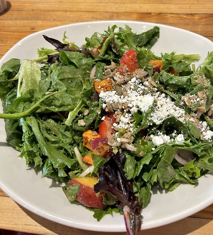 A salad that's having more fun than most entrees. Those strawberries and greens are partying with cheese like it's 1999.