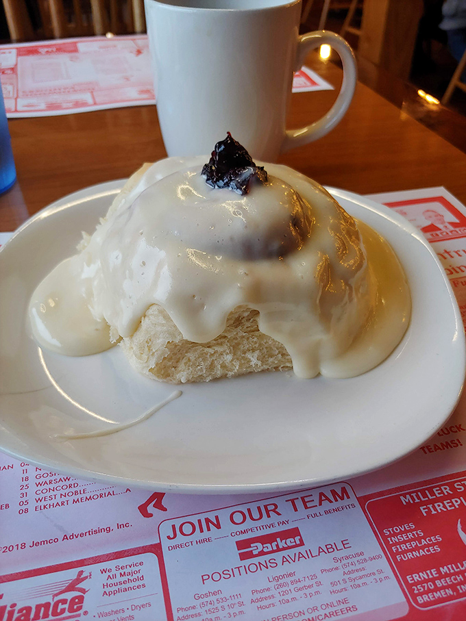 This cinnamon roll isn't just breakfast&mdash;it's dessert masquerading as a morning meal, baptized in glaze and blessed with what appears to be fruit preserves.