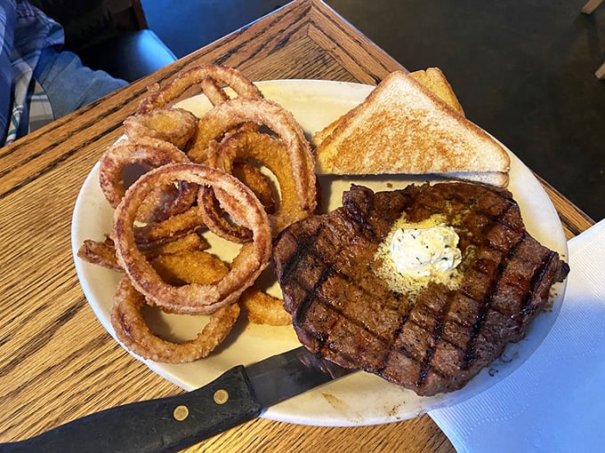This isn't just a steak – it's a masterclass in grilling, complete with those onion rings that shatter satisfyingly between your teeth like crispy golden halos.