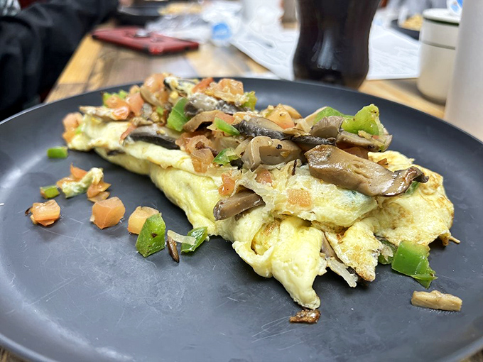 An omelet that doesn't hold back on the veggies. Mushrooms and peppers having their moment in the spotlight, with eggs as their willing canvas. 