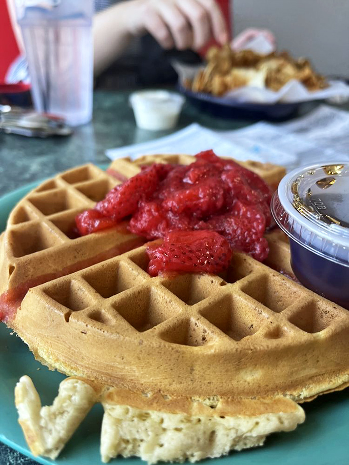 That waffle isn't just breakfast&mdash;it's edible architecture with perfect pockets designed specifically for holding strawberry treasure.
