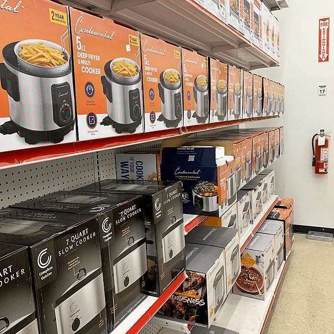 Air fryers and slow cookers lined up like soldiers ready to revolutionize your kitchen routine. Convenience meets affordability on this impressive shelf.