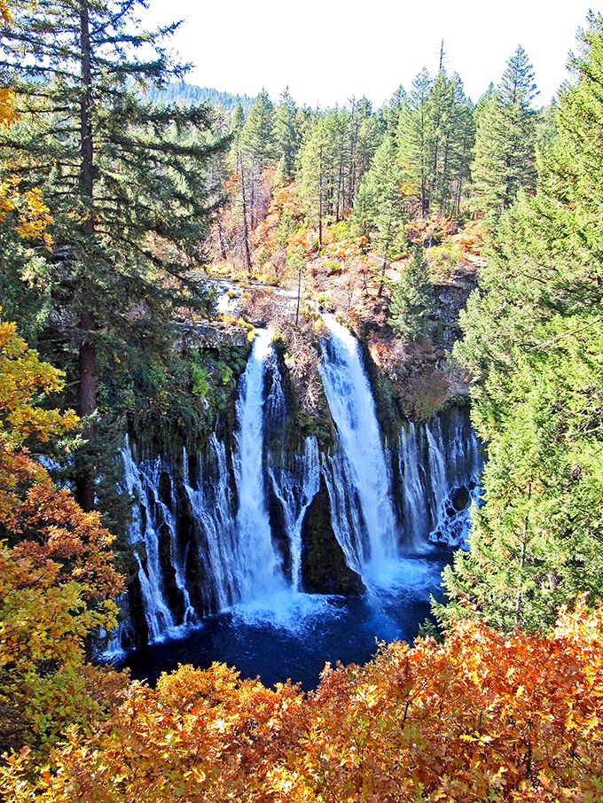 Fall foliage frames the falls in October, proving that even perfection can be improved with the right accessories.