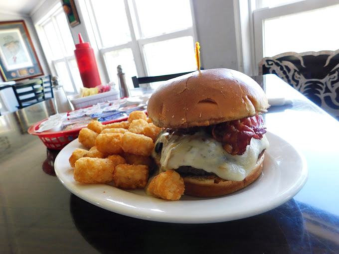 A burger that doesn't care it's breakfast time, defiantly delicious with melted cheese and accompanied by golden tots that crunch like rhythm sections.