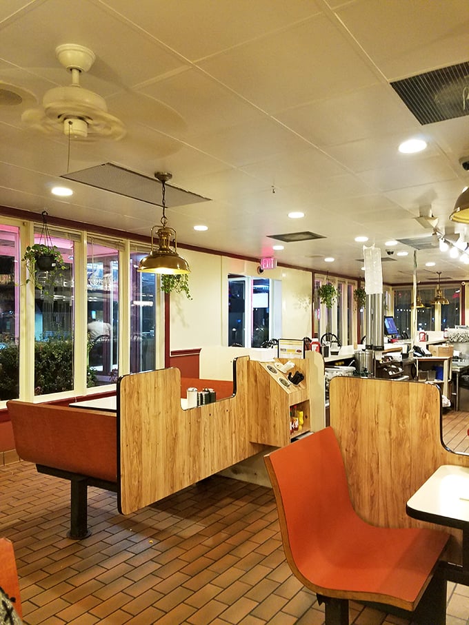Classic diner architecture at its finest&mdash;wooden booth dividers and hanging plants creating little islands of privacy in a sea of shared experience.