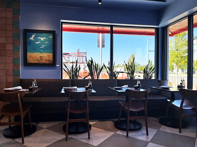 Sunlight streams through large windows, illuminating a dining space where local art and comfortable seating create the perfect breakfast backdrop.