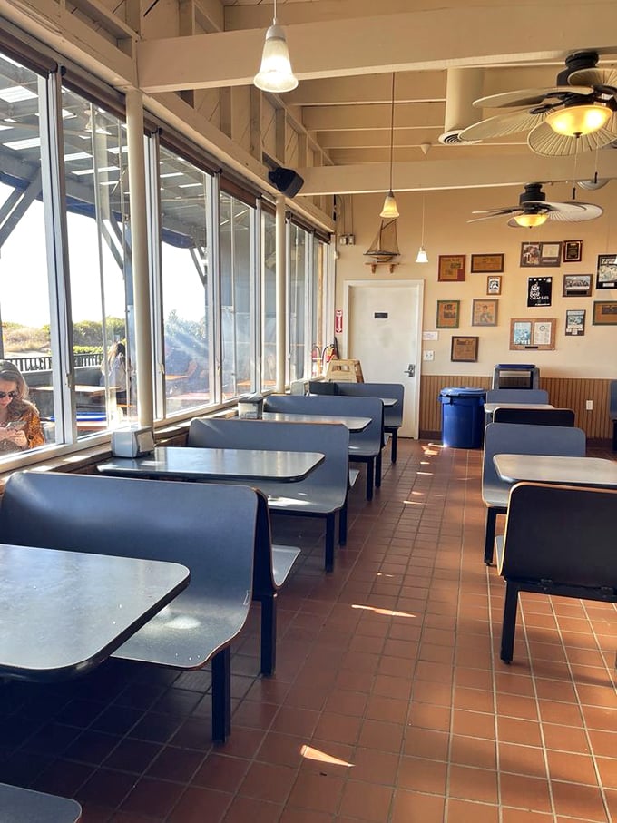 Sunlight streams through windows framing the Pacific, turning an ordinary lunch into a California postcard moment. Those blue booths have stories to tell.