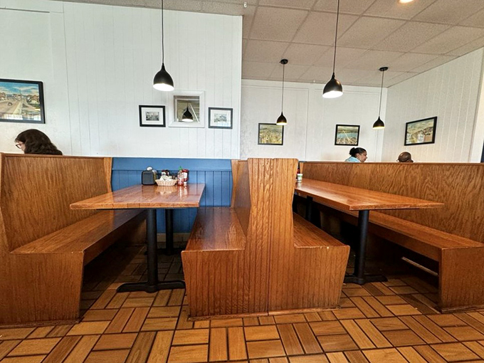 Wooden booths with blue accents create that classic diner feel where breakfast memories are made and pancake dreams come true.