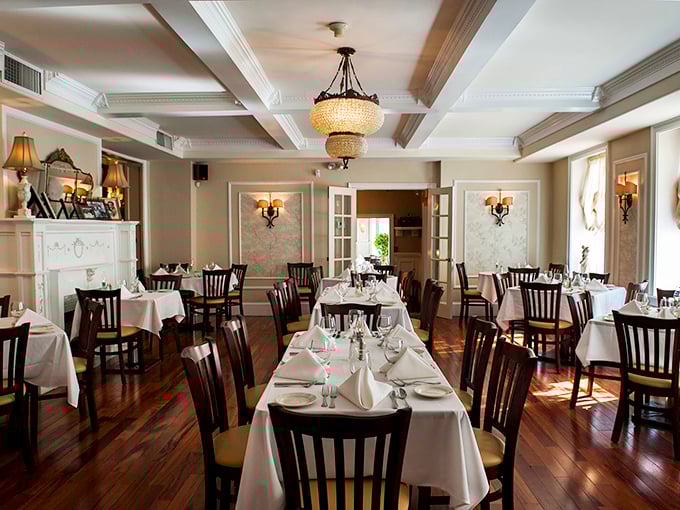 Chandeliers, white tablecloths, and hardwood floors create the perfect stage for culinary theater. Even empty, this room tells stories of memorable meals.