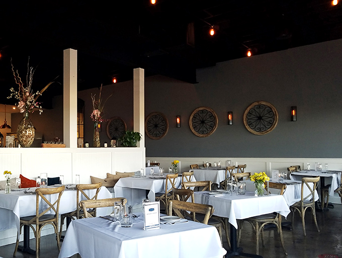 The dining room feels like the living room of that friend who has impeccable taste but never makes you feel underdressed. Those circular wall accents add just the right touch of maritime charm.