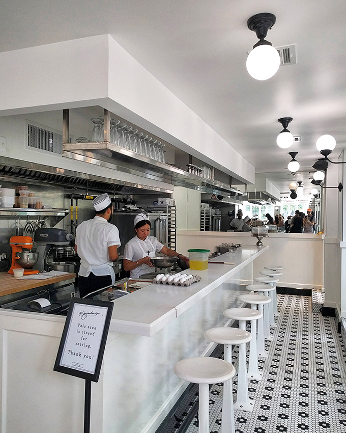The open kitchen design lets you witness the magic happening. Like watching Olympic athletes, but their sport is making perfect ice cream.