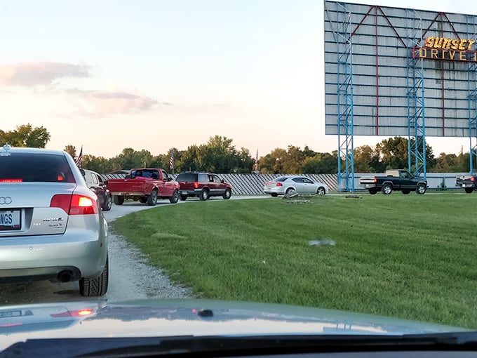 The distinctive blue framework of the Sunset sign welcomes a line of cars, each filled with people creating memories that will outlast any blockbuster.