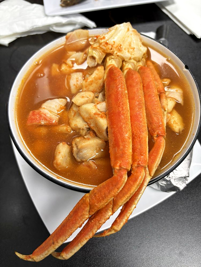 Crab legs reaching dramatically from the broth like they're auditioning for a seafood ballet. This soup is what comfort looks like in oceanic form.