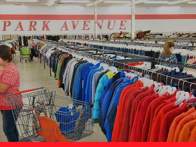 The "PARK AVENUE" sign presides over a rainbow of clothing options while shoppers navigate the sea of secondhand fashion.