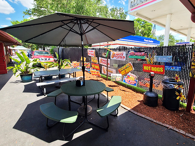 The outdoor dining area feels like a backyard cookout where everyone's invited. Those signs on the fence? They're not decoration&mdash;they're a manifesto.