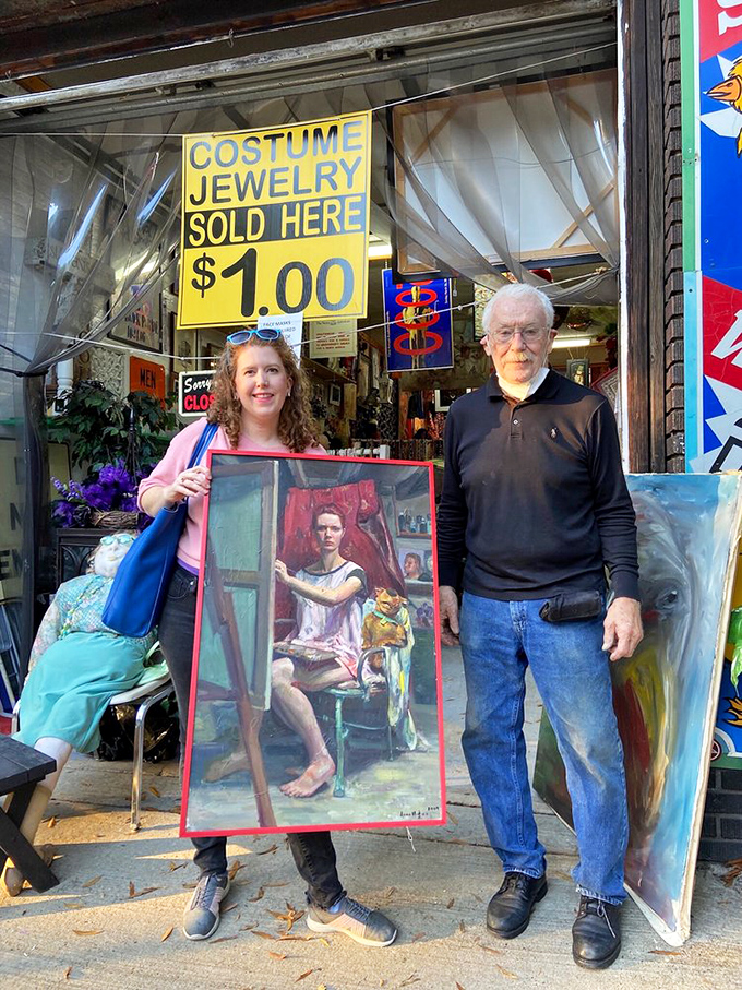 Happy treasure hunters display their artistic find outside the shop. One person's oddity is another's masterpiece&mdash;the thrill of the hunt realized.