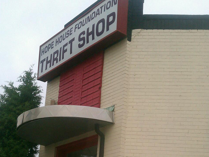 The bold red accent against white brick makes this thrift store pop like a beacon of budget-friendly possibilities.