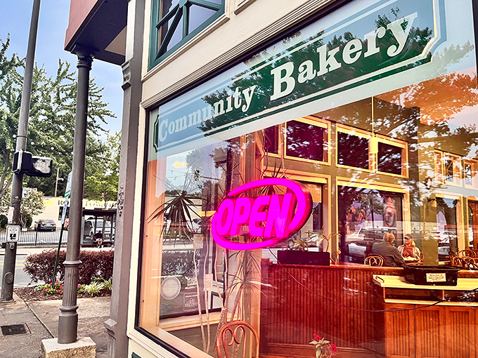 The iconic teal-trimmed entrance of Community Bakery beckons like an old friend, promising carb-laden treasures behind that glowing "OPEN" sign.
