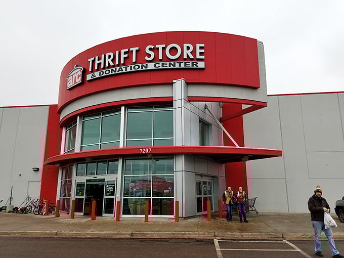 The bold red entrance of Arc Thrift Store beckons like a retail lighthouse, promising treasure hunters the thrill of discovery within its cavernous interior.