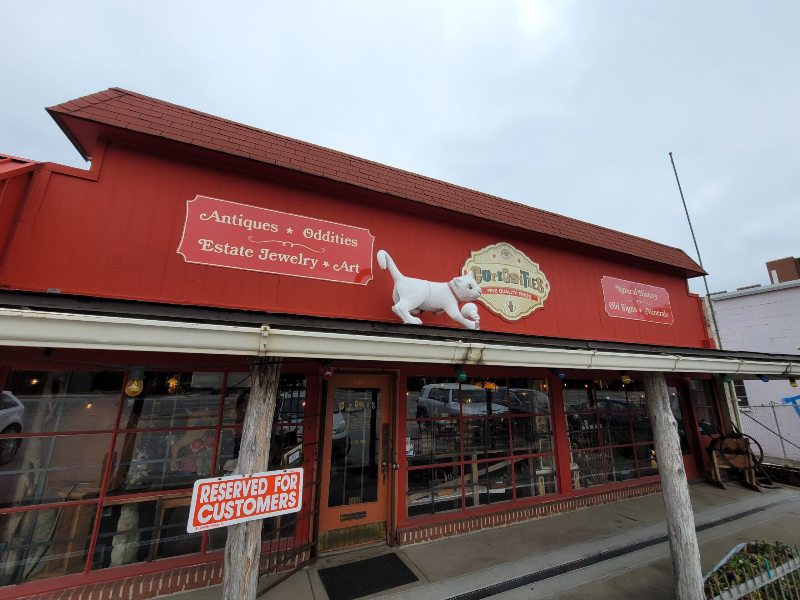 The vibrant red exterior of Curiosities stands out like a beacon of eccentricity, promising treasures that would make any collector's heart skip a beat.