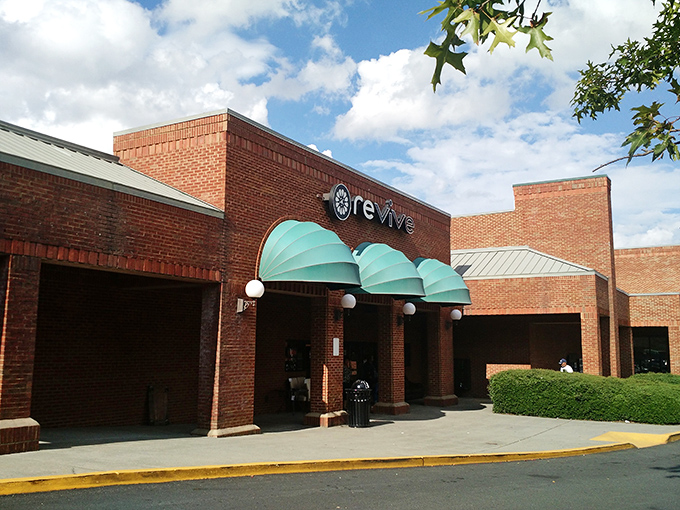 The brick façade and teal awnings of Revive Consignment stand like a beacon of bargain-hunting hope in Woodstock, inviting treasure-seekers to step inside and discover.