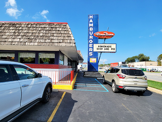 That classic blue "HAMBURGERS" sign isn't just roadside decor—it's a bat signal for those who appreciate the difference between fast food and food worth slowing down for.