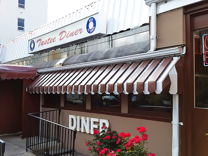 The stainless steel exterior of Tastee Diner stands defiant against time, its red and white awning a beacon for breakfast pilgrims seeking authenticity in Bethesda.