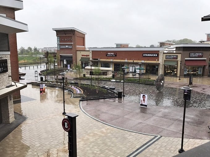 The grand entrance to Clarksburg Premium Outlets stands like a retail Colosseum, beckoning bargain hunters with promises of designer treasures within.