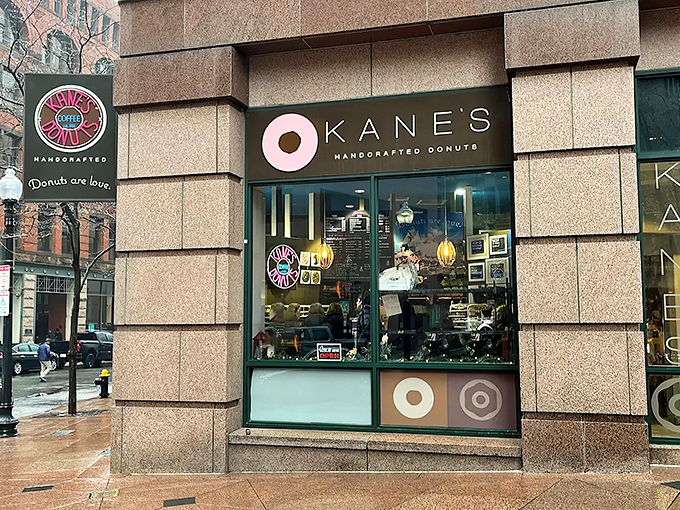 Kane's iconic storefront in Boston's Financial District beckons like a pink-glazed lighthouse to donut lovers navigating the urban sea of steel and stone.