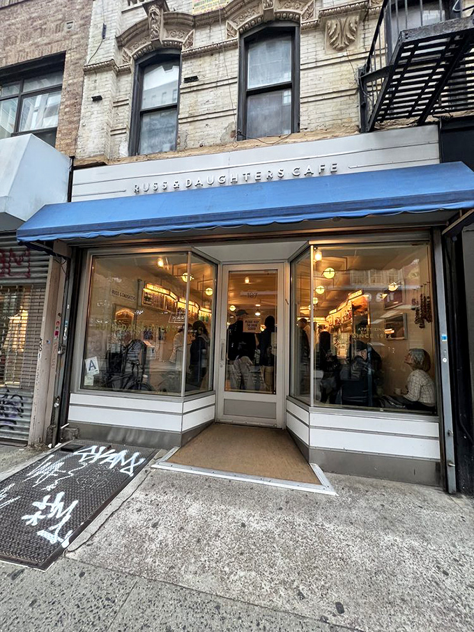The iconic blue awning of Russ & Daughters Cafe stands out like a culinary lighthouse, guiding hungry souls to this Lower East Side institution.