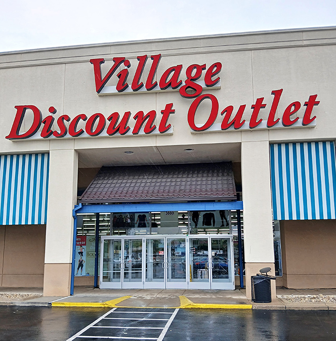 The iconic red signage of Village Discount Outlet beckons like a lighthouse for bargain hunters. Blue awnings and a spacious parking lot welcome treasure seekers of all kinds.