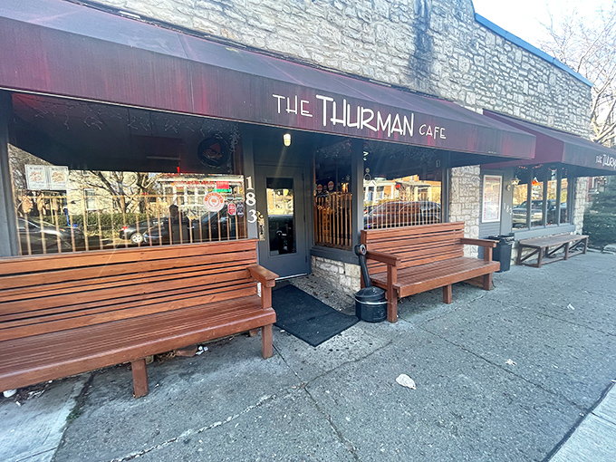 The unassuming stone exterior with its crimson awning doesn't scream "burger legend," but the wooden benches outside hint at something worth waiting for.