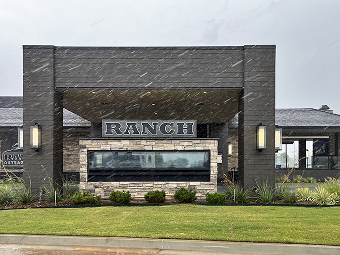The modern stone facade of Ranch Steakhouse stands confidently against the Oklahoma sky, like a culinary fortress promising delicious treasures within.