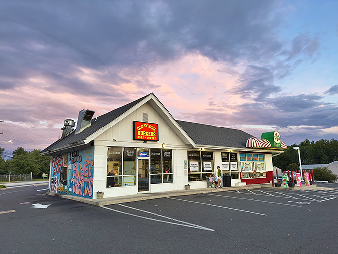 Old School Burgers glows like a beacon at twilight, its colorful mural promising flavor adventures within. The perfect neighborhood joint where memories are made.
