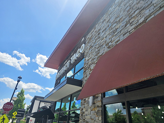 The rustic wooden exterior of District Taco welcomes hungry visitors with its vibrant sign and colorful flower boxes&mdash;a taco oasis in King of Prussia.