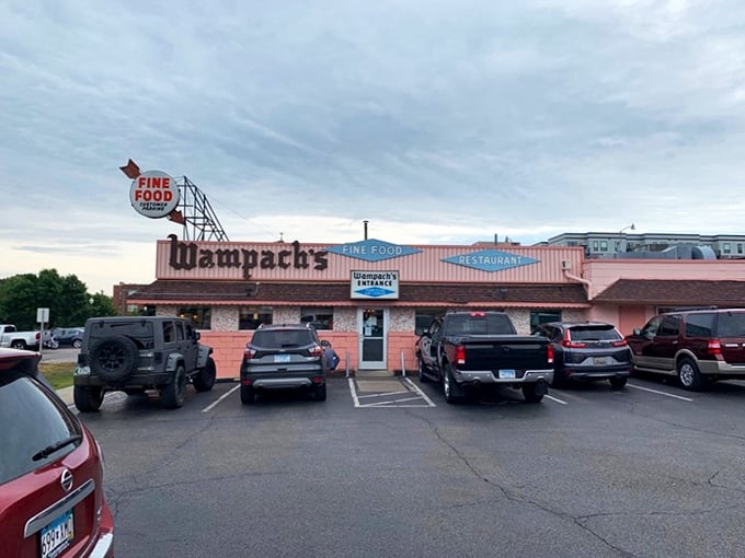 The pink brick facade of Wampach's stands like a time capsule, promising "FINE FOOD" with the confidence of someone who's been keeping that promise for decades.