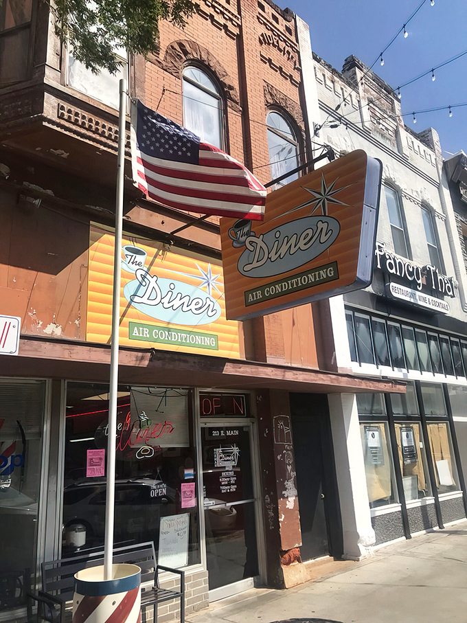 That vintage orange and teal sign isn't just advertising air conditioning&mdash;it's promising a time machine to when breakfast was an event worth getting dressed for.