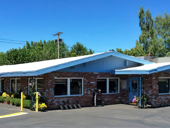 The unassuming brick exterior of Sybil's belies the breakfast magic happening inside. Blue trim and waiting benches hint at the diner's popularity.