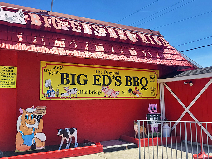 The barn-red exterior of Big Ed's BBQ stands out like a beacon for hungry travelers, complete with whimsical pig and cow cartoons that promise delicious things inside.
