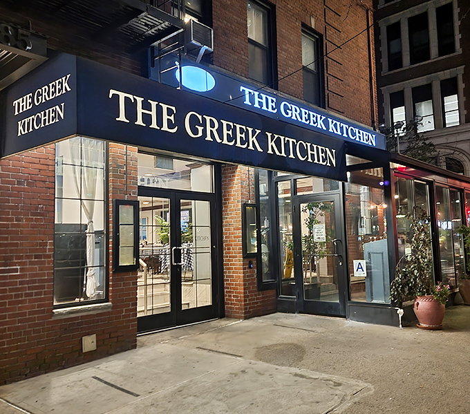 The blue awning of The Greek Kitchen beckons like a Mediterranean oasis amid Manhattan's brick landscape. Your Aegean adventure awaits!