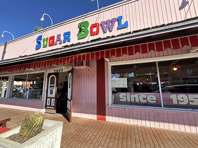 The iconic pink facade of Sugar Bowl stands as a sweet beacon in Old Town Scottsdale, its colorful lettering promising frozen happiness inside.