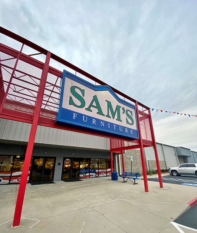 The iconic red entrance of Sam's Furniture stands out like a Broadway marquee, complete with a patriotic inflatable tube man welcoming shoppers to the furniture wonderland.