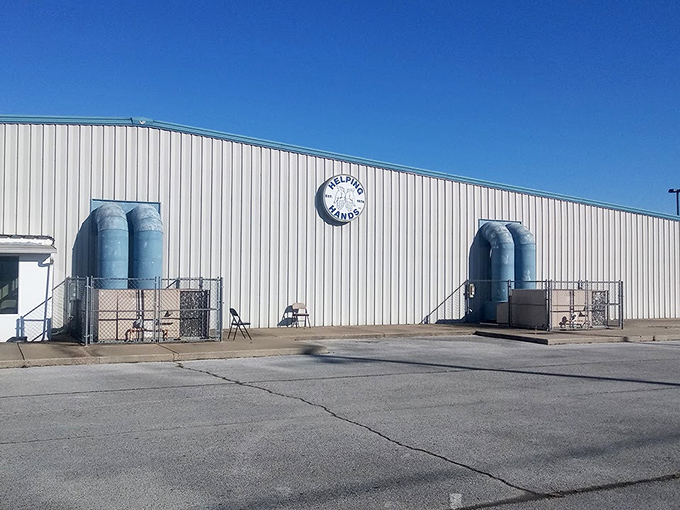 The bright blue facade of Helping Hands stands like a beacon of bargain-hunting hope against the Arkansas sky, promising treasures within.