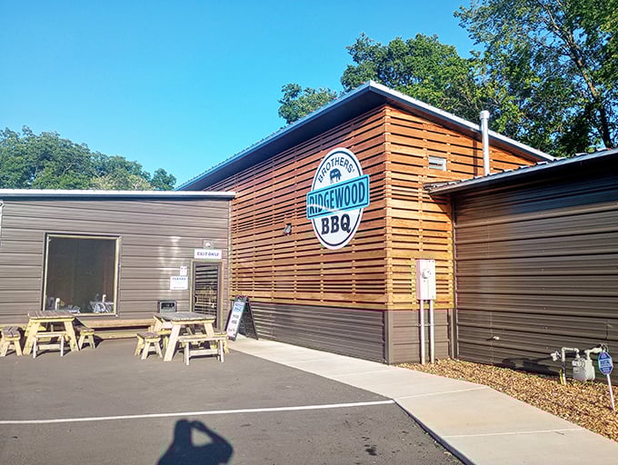 The modern wooden facade of Ridgewood Brothers BBQ stands like a beacon of hope for hungry travelers. Simple picnic tables outside hint at the no-frills focus on what matters most: the meat.