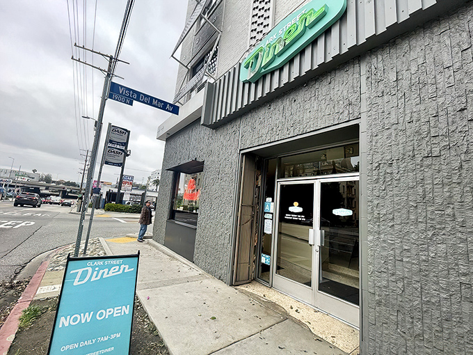 The iconic teal sign of Clark Street Diner beckons from beneath a Hollywood apartment building like a neon promise of comfort food salvation.