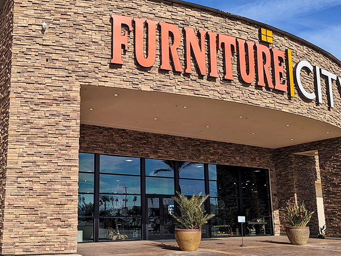 The grand entrance to Furniture City beckons with its impressive stone facade and bold signage—like the pearly gates of home decor heaven.