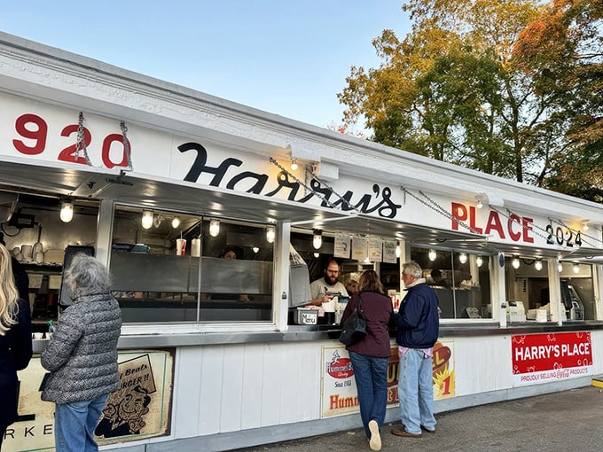The white facade of Harry's Place stands like a culinary lighthouse, beckoning hungry travelers with its iconic red lettering and promise of roadside bliss.